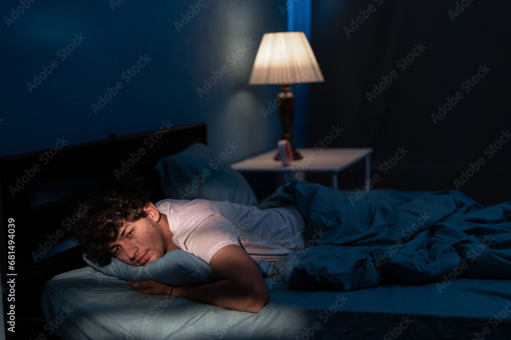 Arab man suffering from insomnia lying in bed with open eyes. Handsome ...