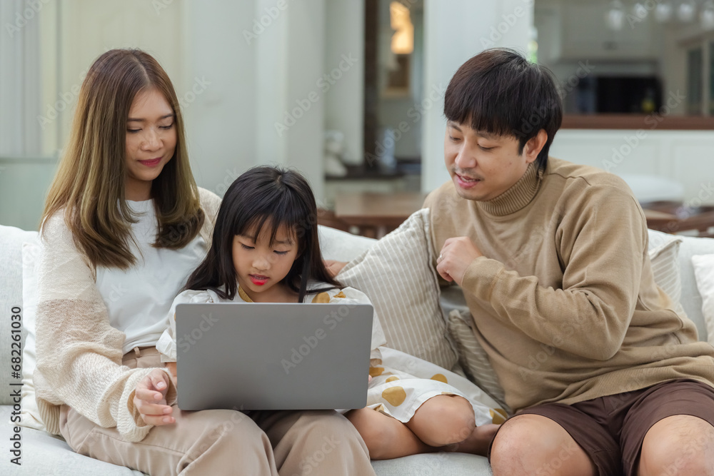 Happy asian family father mother and child daughter having fun using ...