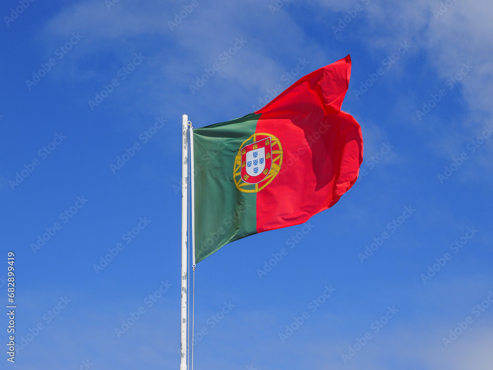 Flag of Portugal in the blue cloudy sky background. Bandeira de ...
