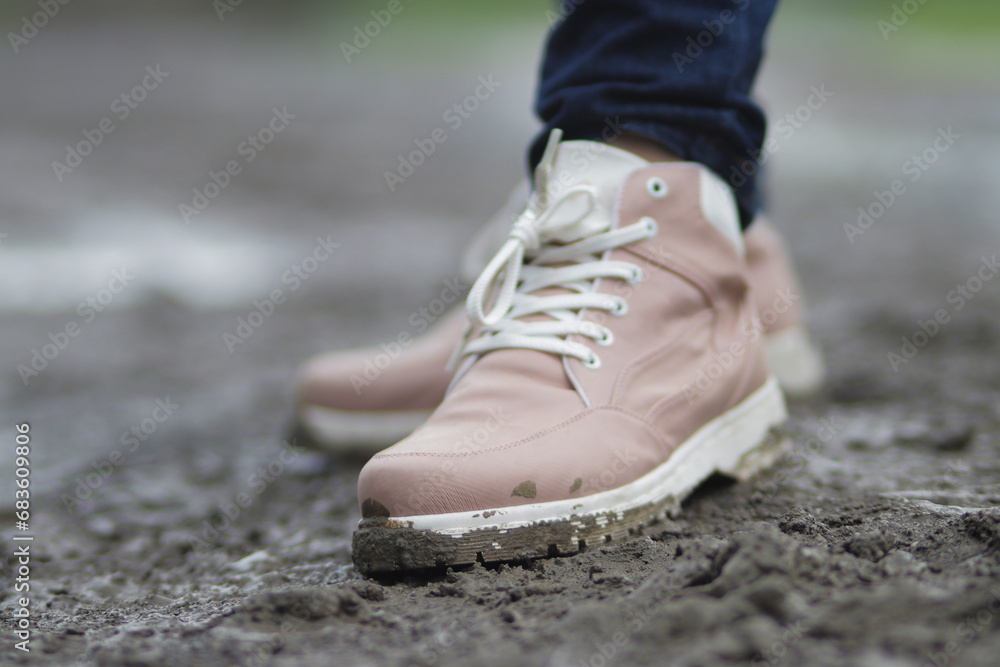 Woman wears new sneaker shoes, now covered in mud, while embarking on ...