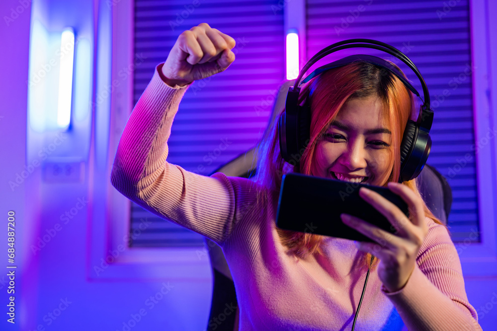 Winning. Happy Gamer playing video game online with smartphone with ...