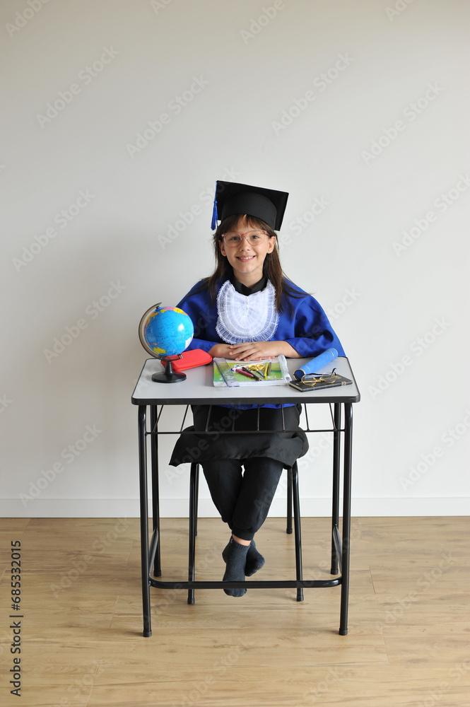formanda infantil com beca e capelo uniforme de formatura em mesa ...