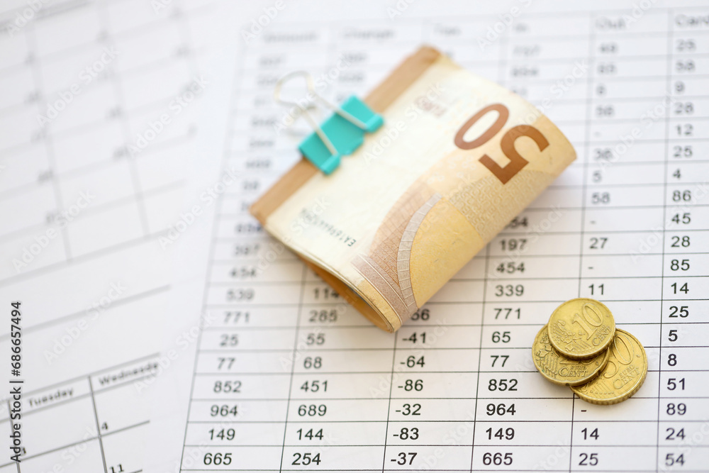 Heap of euro money bills in stationery clip on papers with calculations ...