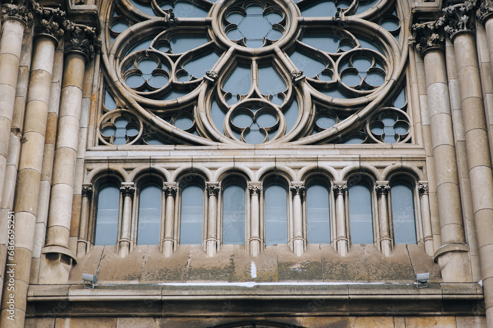 Round openwork window with stained glass on the facade of the building ...