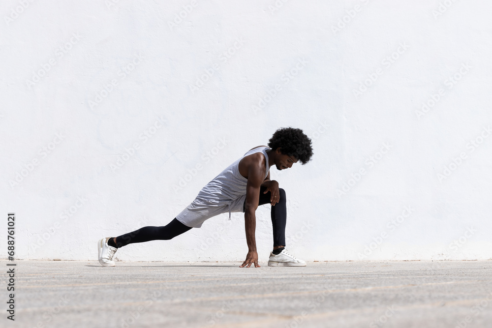 Side view of concentrated black male athlete in sportswear and sneakers ...