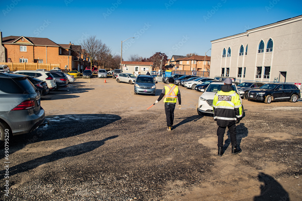 Security guard conducting access control, traffic control, and parking ...