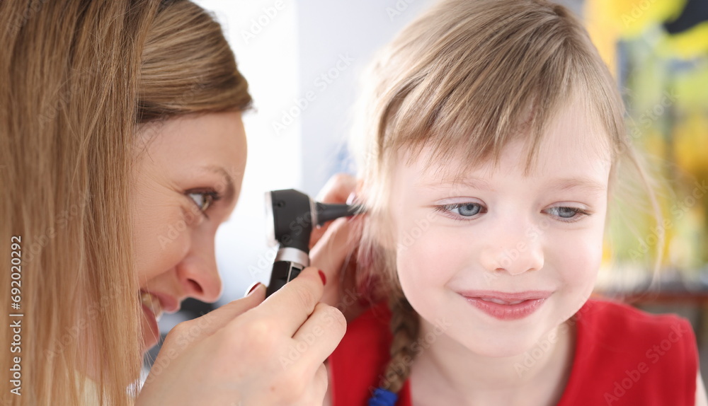 Otorhinolaryngologist looking at sore ear of little girl. Ear ...