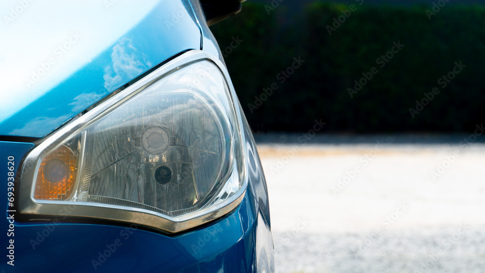 Headlights of bue car. with sunlight casting a radiant glow on the hood ...