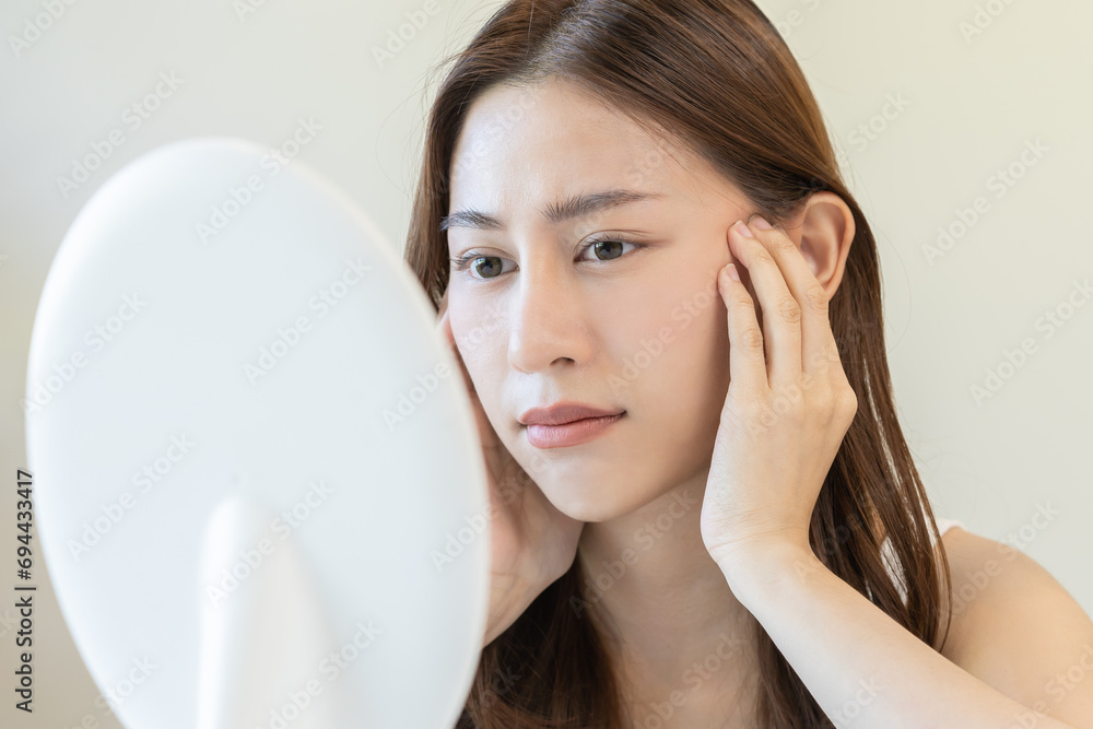 Dermatology, puberty asian young woman, girl looking into mirror ...