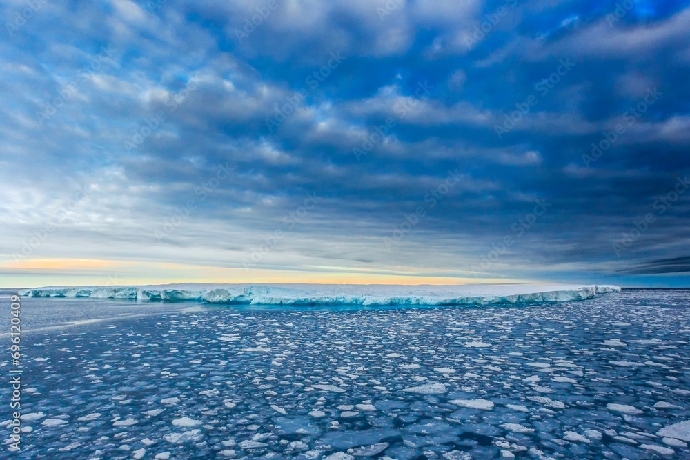 Giant iceberg floating in the Arctic sea surrounded by little icebergs ...