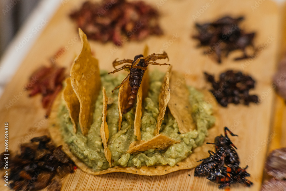 Delicious insect board with guacamole and toast, with grasshoppers ...