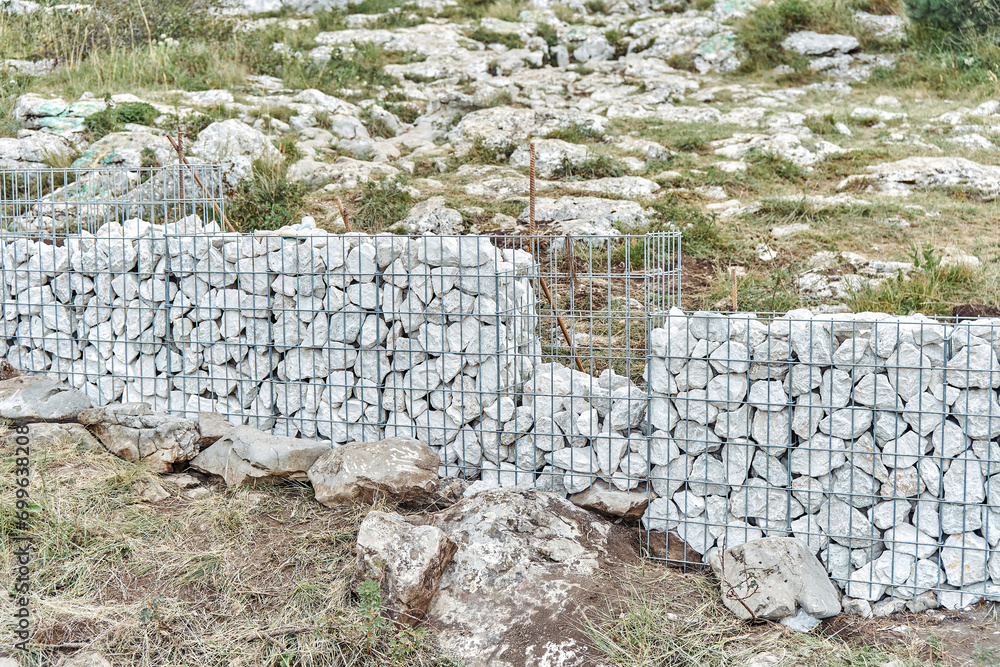 Gabion building process. Gabion building of rocks and metal mesh in ...