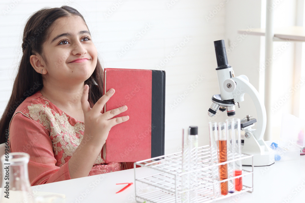 Cute Indian school girl in India traditional dress costume reading book ...