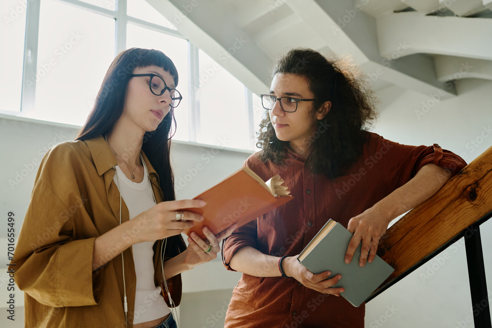 Friends having discussion over book at staircase Stock Photo | Adobe Stock
