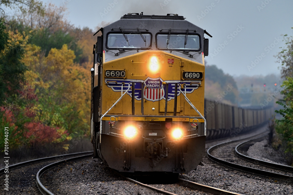 Locomotives lead a Union Pacific Railroad coal train up a grade and ...