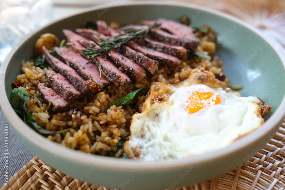 Blurred of Beef basil fried rice dish served with grilled Medium Rare ...
