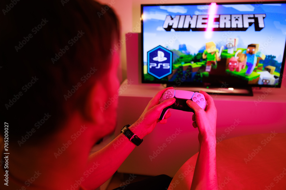 PlayStation 5 game Minecraft. New Sony PS5 console. Dualsense controller. Man holding joystick ...