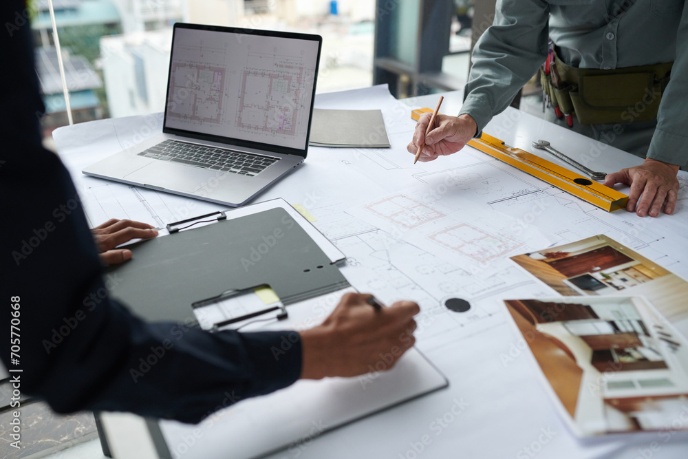 Hands of architects working on building blueprint for client Stock ...