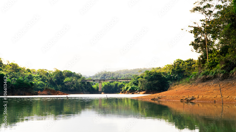 Reflejo de montañas y arboles en el agua de una represa en Colombia con ...