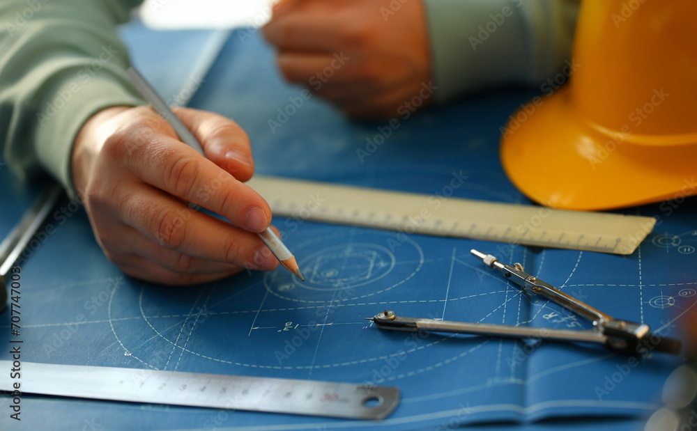 Male hand holding pencil in hand. Engineering blueprint design for ...
