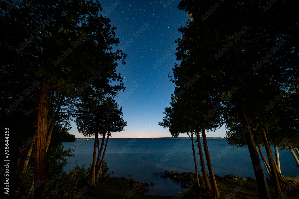 View of night Lake Manitou from the cabin. Dark sky line with stars ...