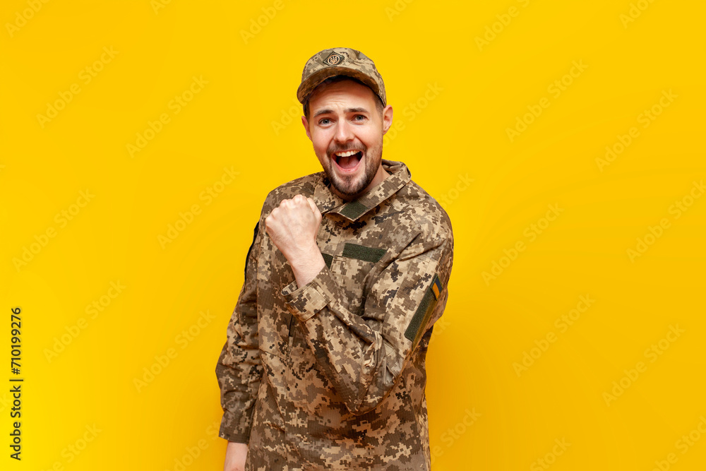 young Ukrainian male soldier in pixel camouflage uniform celebrates ...