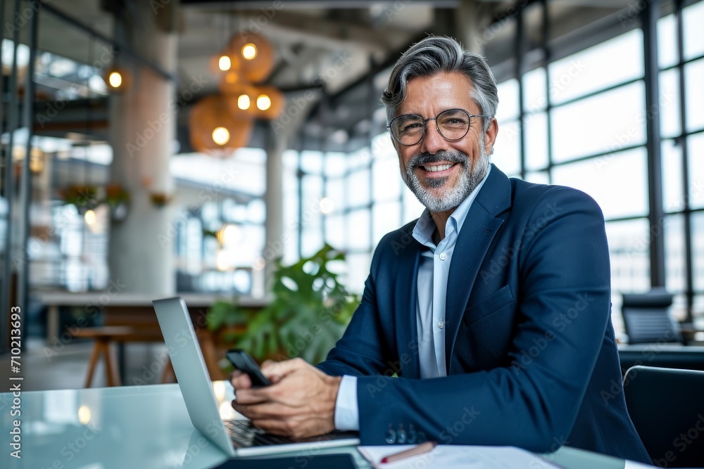 Smiling mid aged business man ceo wearing blue suit sitting in office ...