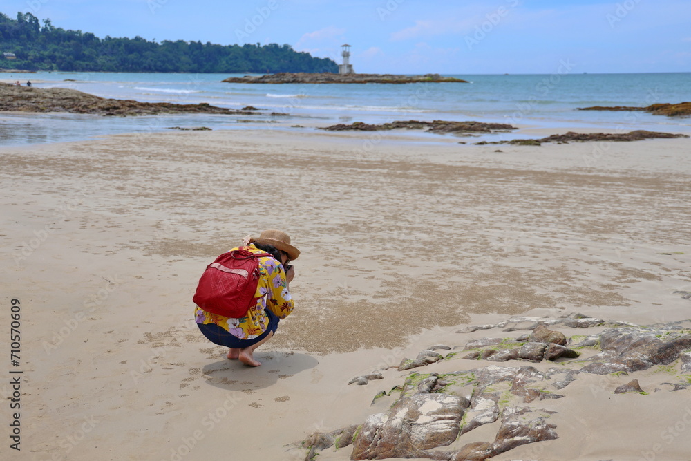 Tourists sit down and use cameras to take pictures of fine sand ...