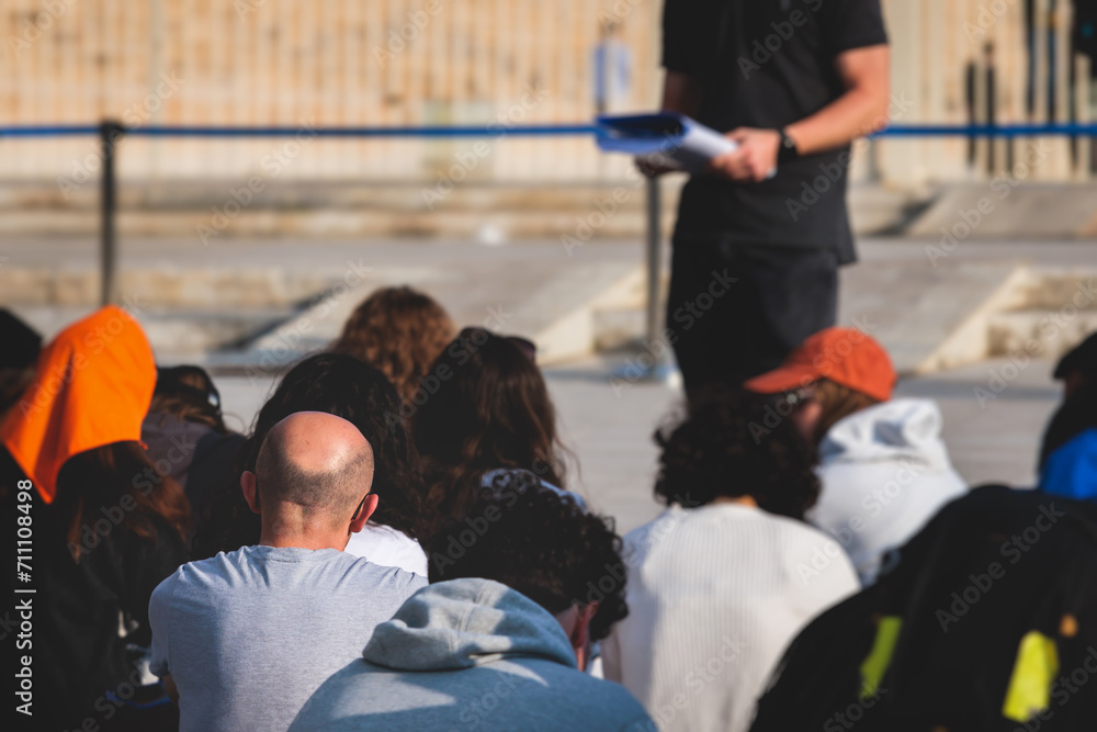 Group of tourists sitting during outdoor excursion tour in the city ...