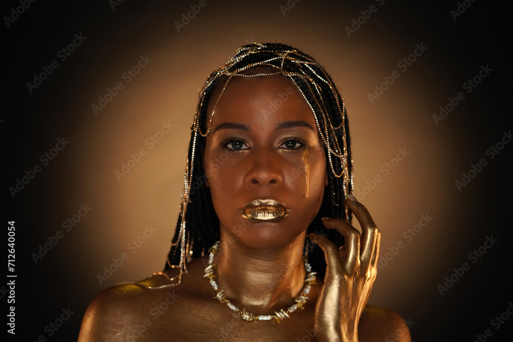 Portrait of an African-American woman with gold jewelry in her hair ...