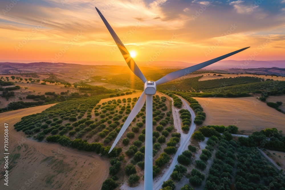 Aerial top view of a wind turbine over an almond field (agricultural ...
