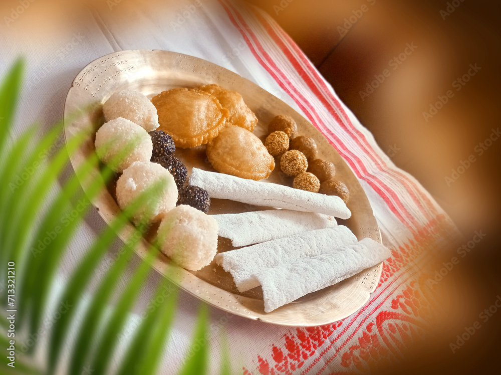 Assamese traditional food items like pitha, laddu, doi sira with ...