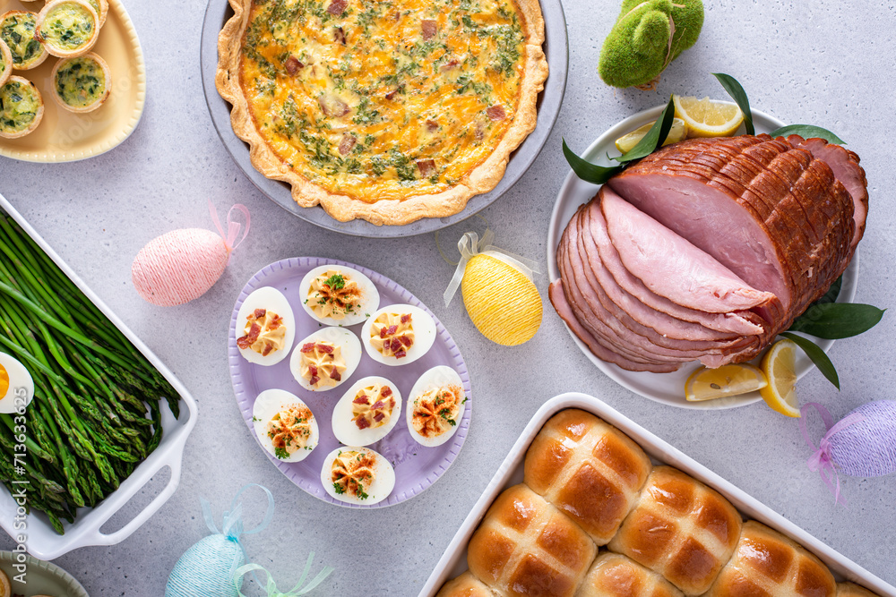 Easter brunch on large table with spiral sliced ham, quiche, deviled ...