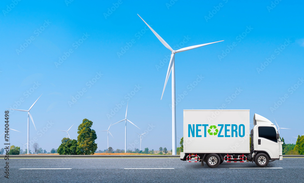 container truck driving on long roads and wind turbine farms behind ...