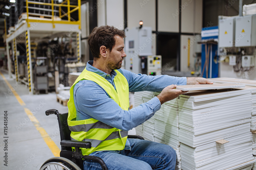 Portrait of man in wheelchair working in modern industrial factory ...