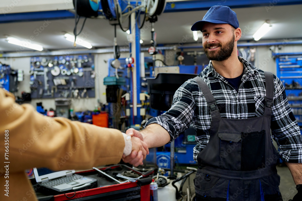 Unity in the workshop: Mechanic and female client share a handshake ...
