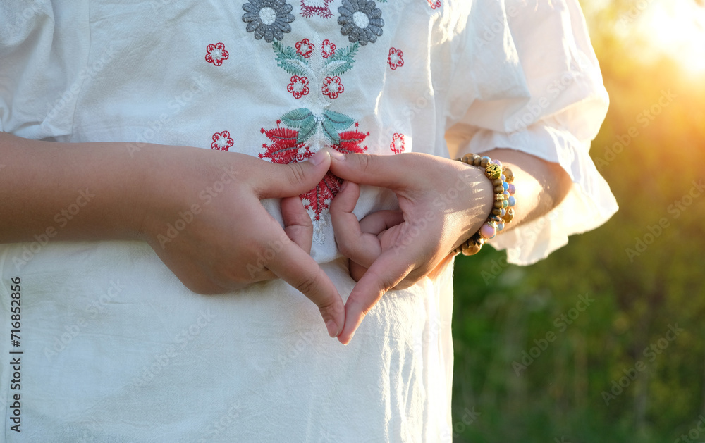 Woman on a white dress outdoor, doing meditation yoga mudra of hands ...