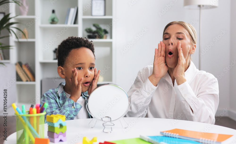 Cute little multiracial boy with speech problems practicing with ...