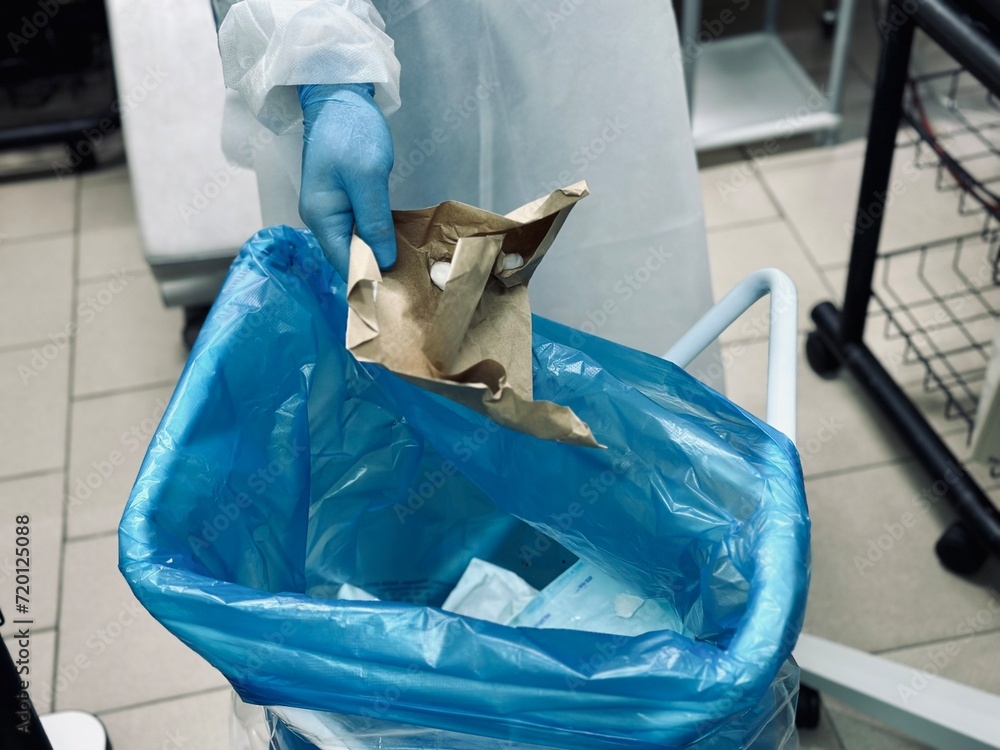 Hospital worker discarding infectious medical waste into disposal ...
