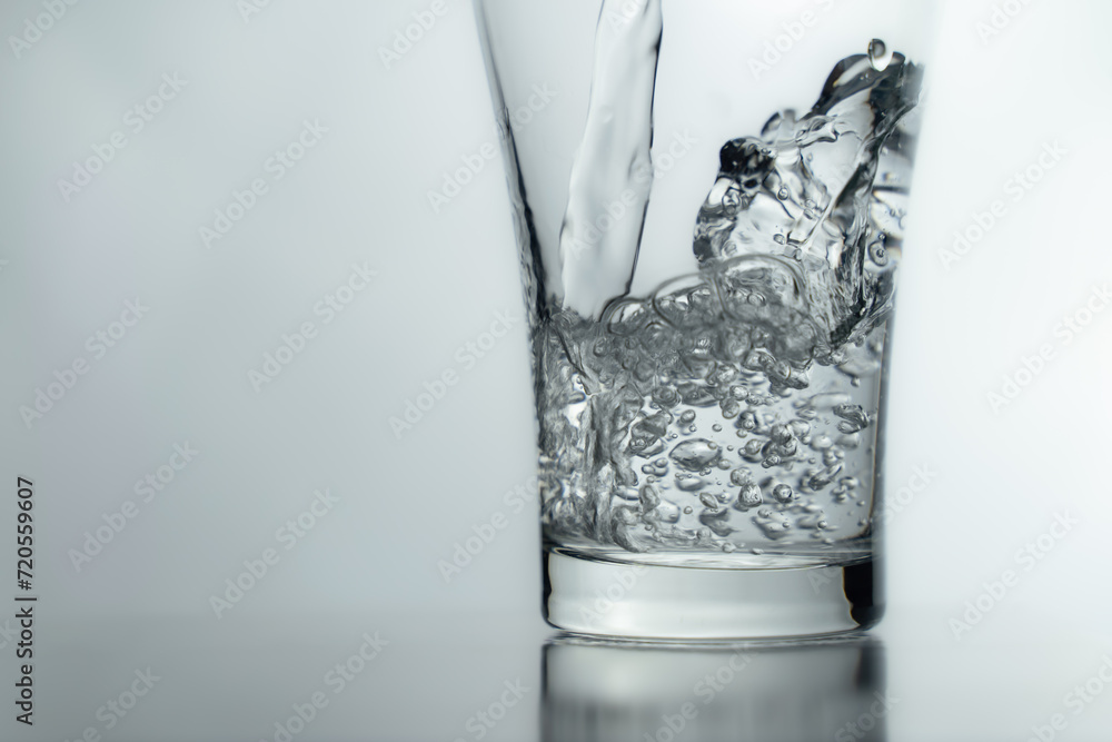pouring water into glass on table, glass of water with splash isolated on white background ...