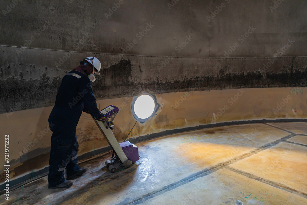 Male worker inspection floor scan tank external floating of rust wall ...