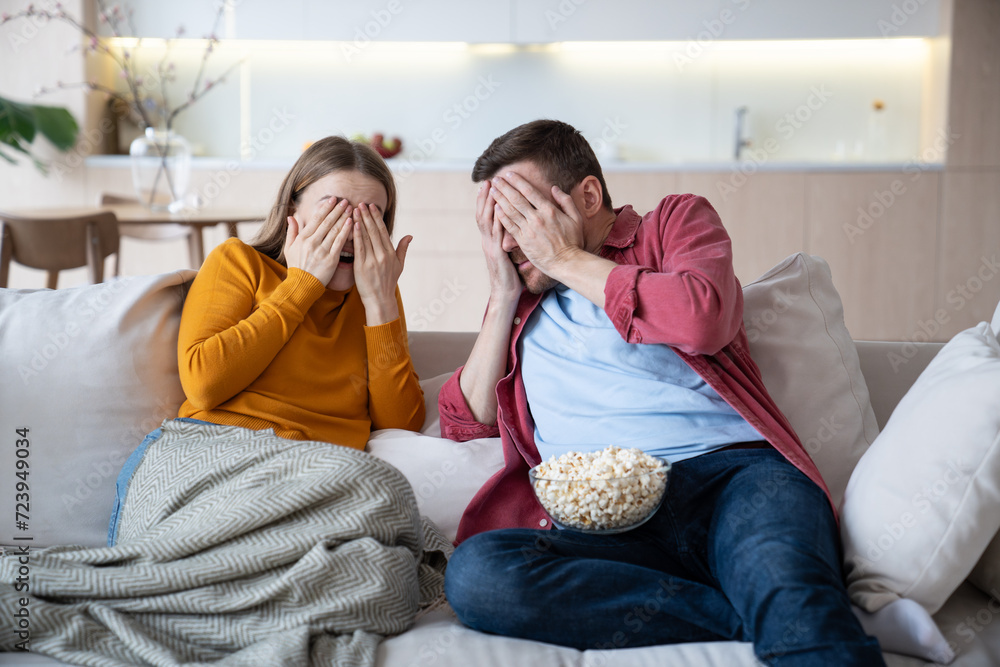 Shocked man and woman closing faces with hands frightened by terrifying ...