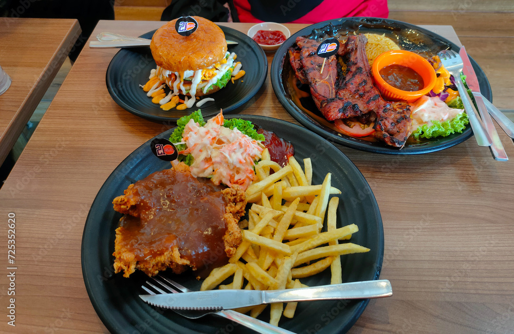 Chicken chop, Arabic rice and burgers that are available on the table ...