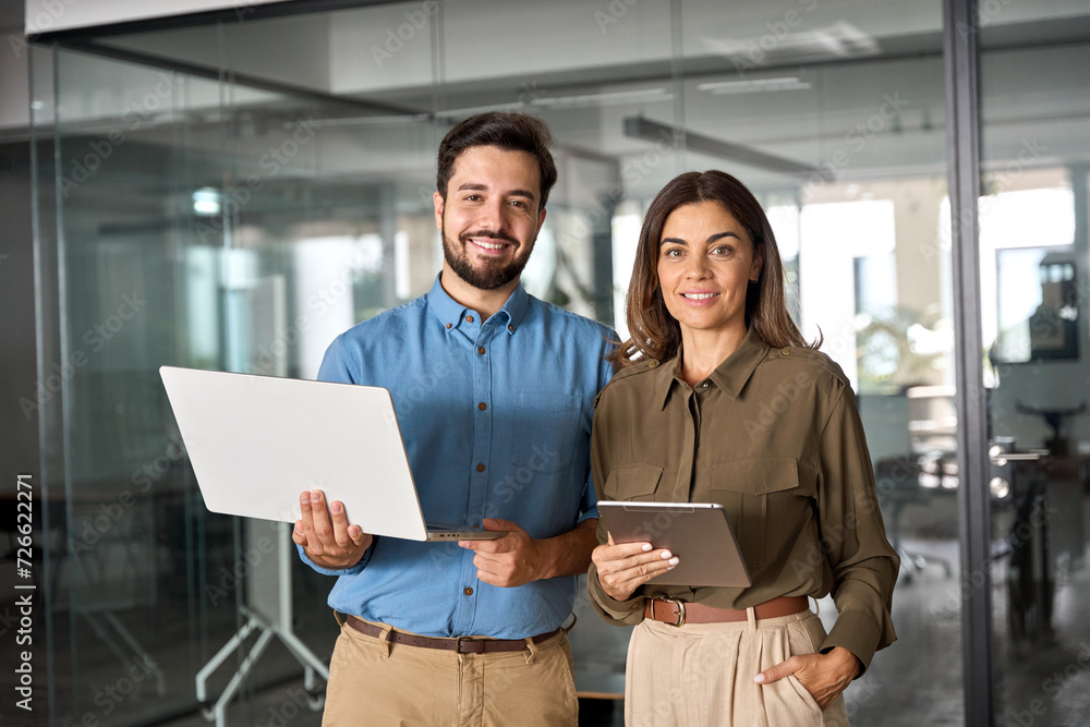 Two business partners executives standing in office looking at camera ...
