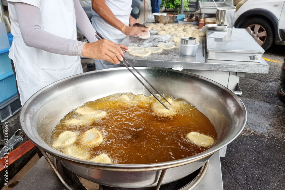 Hawker deep frying the Ham Chim Peng in wok with hot oil, a popular ...