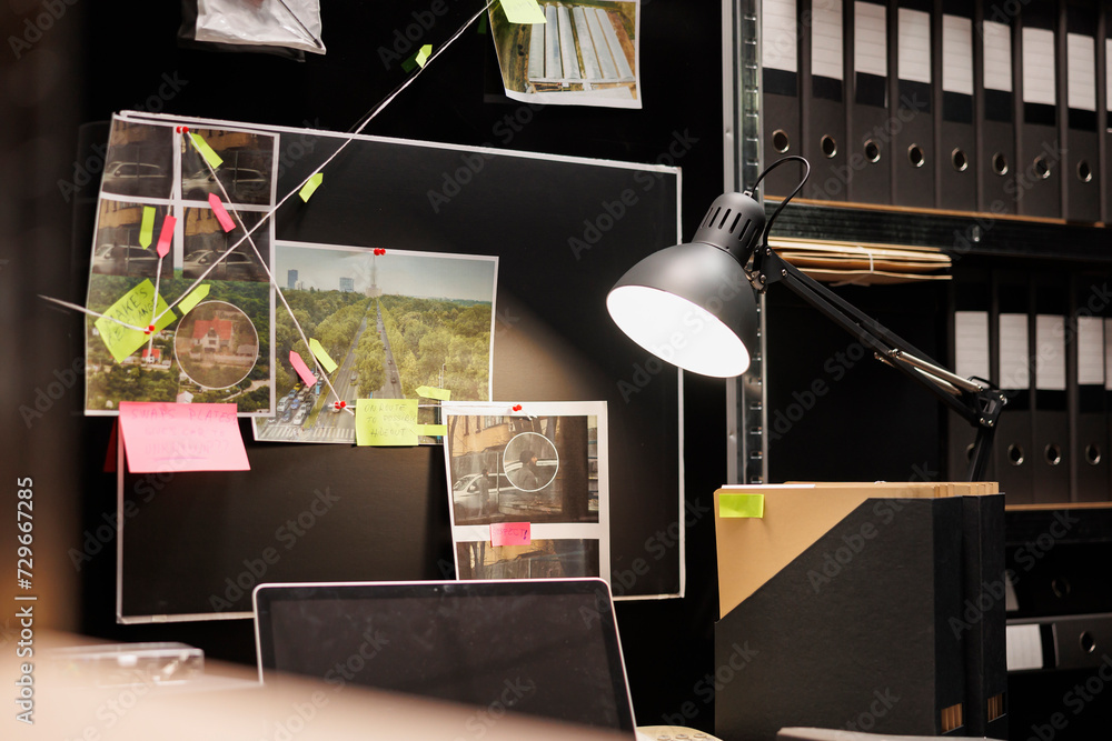 Crime evidence board with investigation process map lit with desk lamp ...