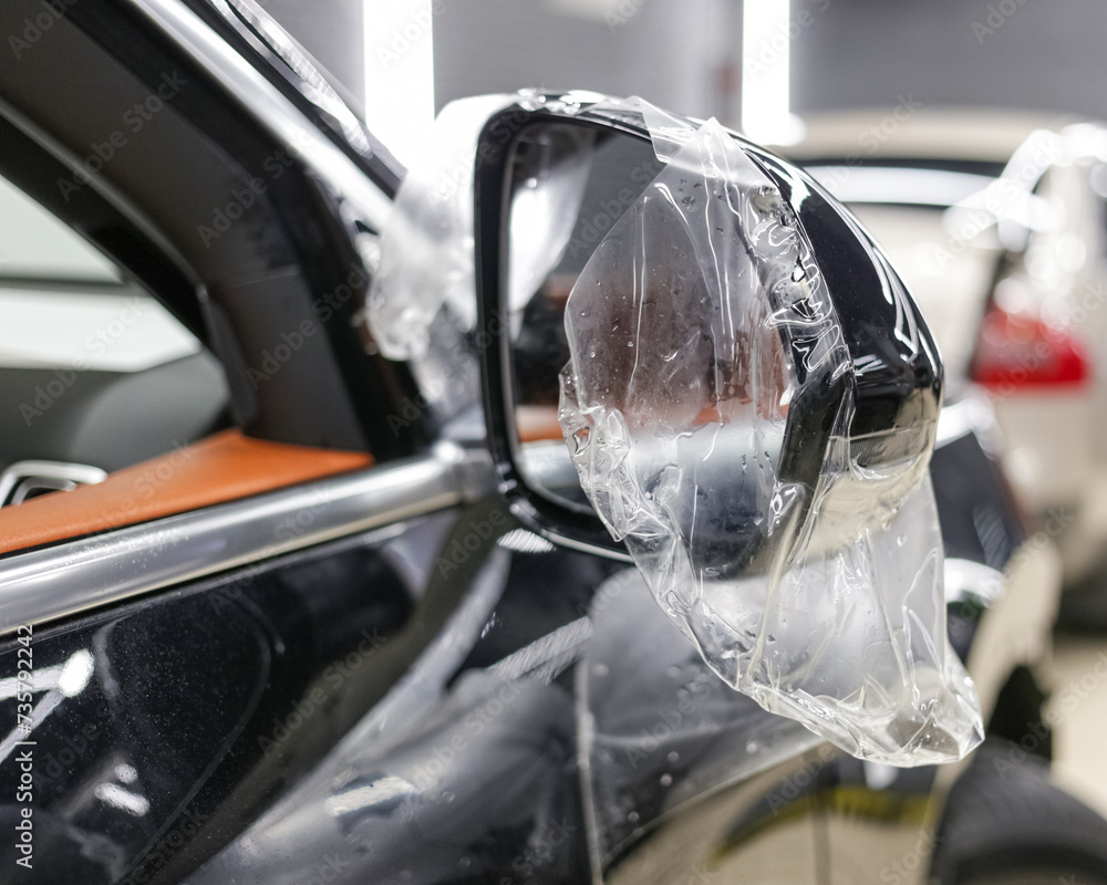The process of installing PPF on the side mirror. PPF is a protective ...
