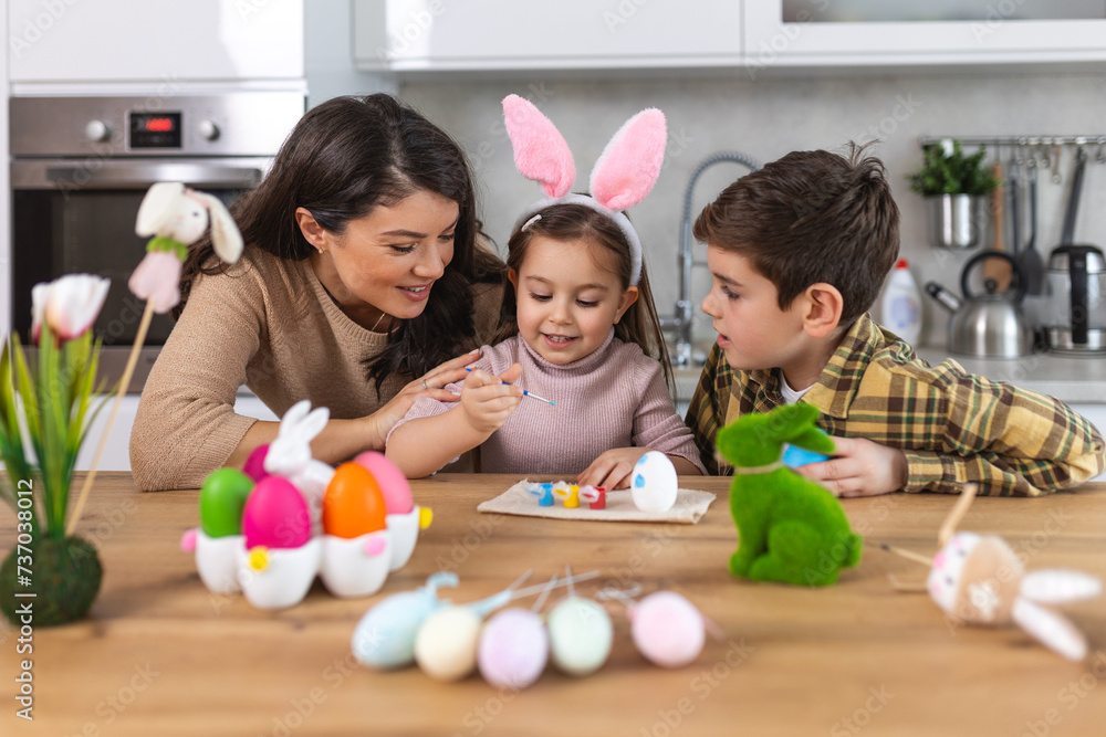 Mother son and daughter celebrating Easter, coloring eggs. Happy family ...
