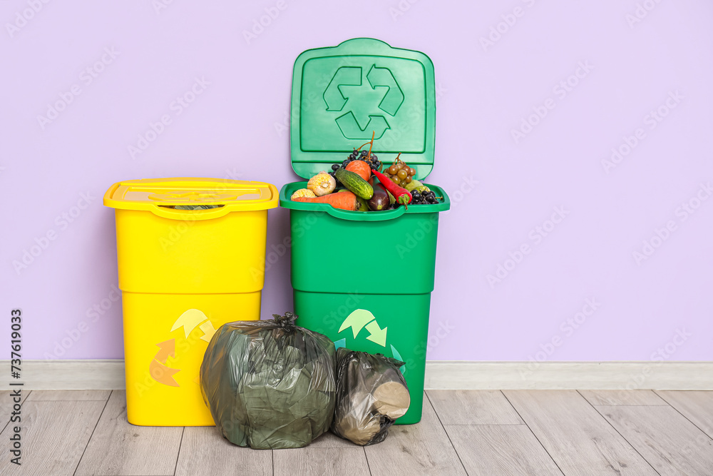 Containers for trash with food waste and full garbage bags near lilac ...