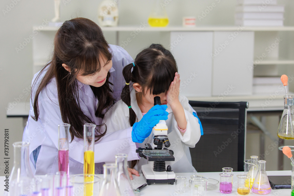 Asian woman teacher and little children girl making science experiments ...